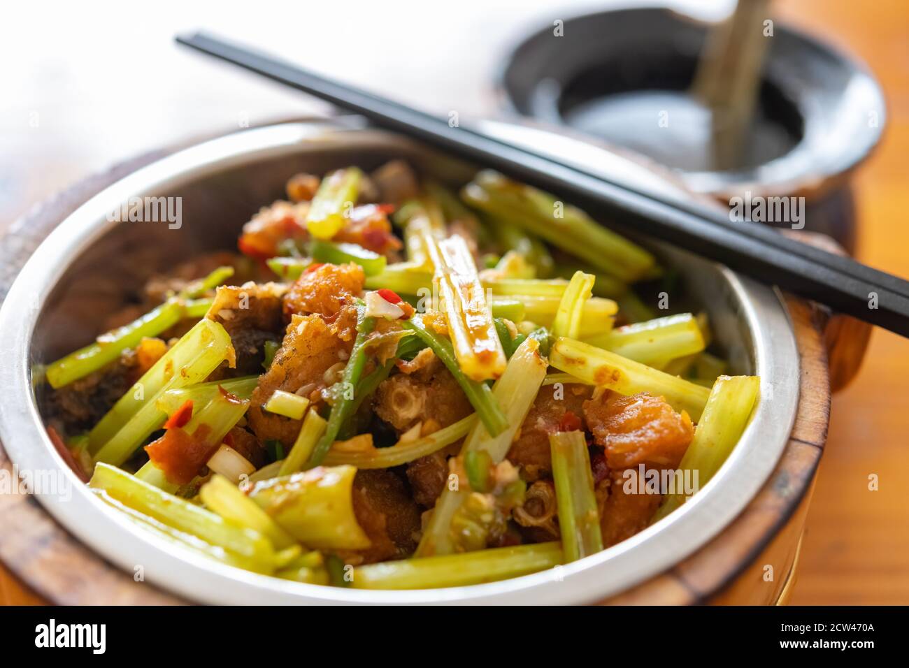 side view fast food of deep fried grass carp and celery with bowl of ...