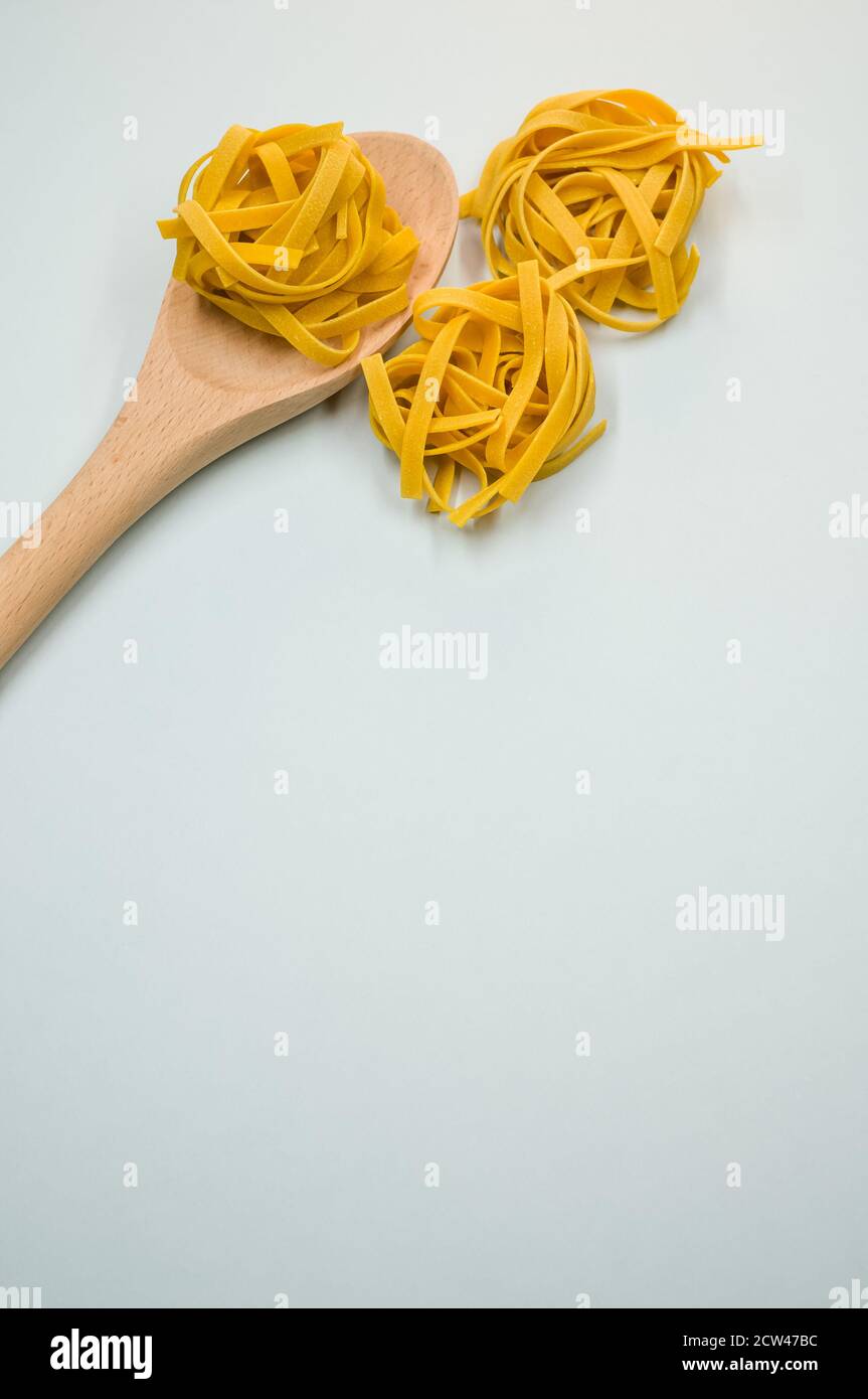 Vertical shot of tagliatelle pasta and a wooden kitchen tool Stock ...