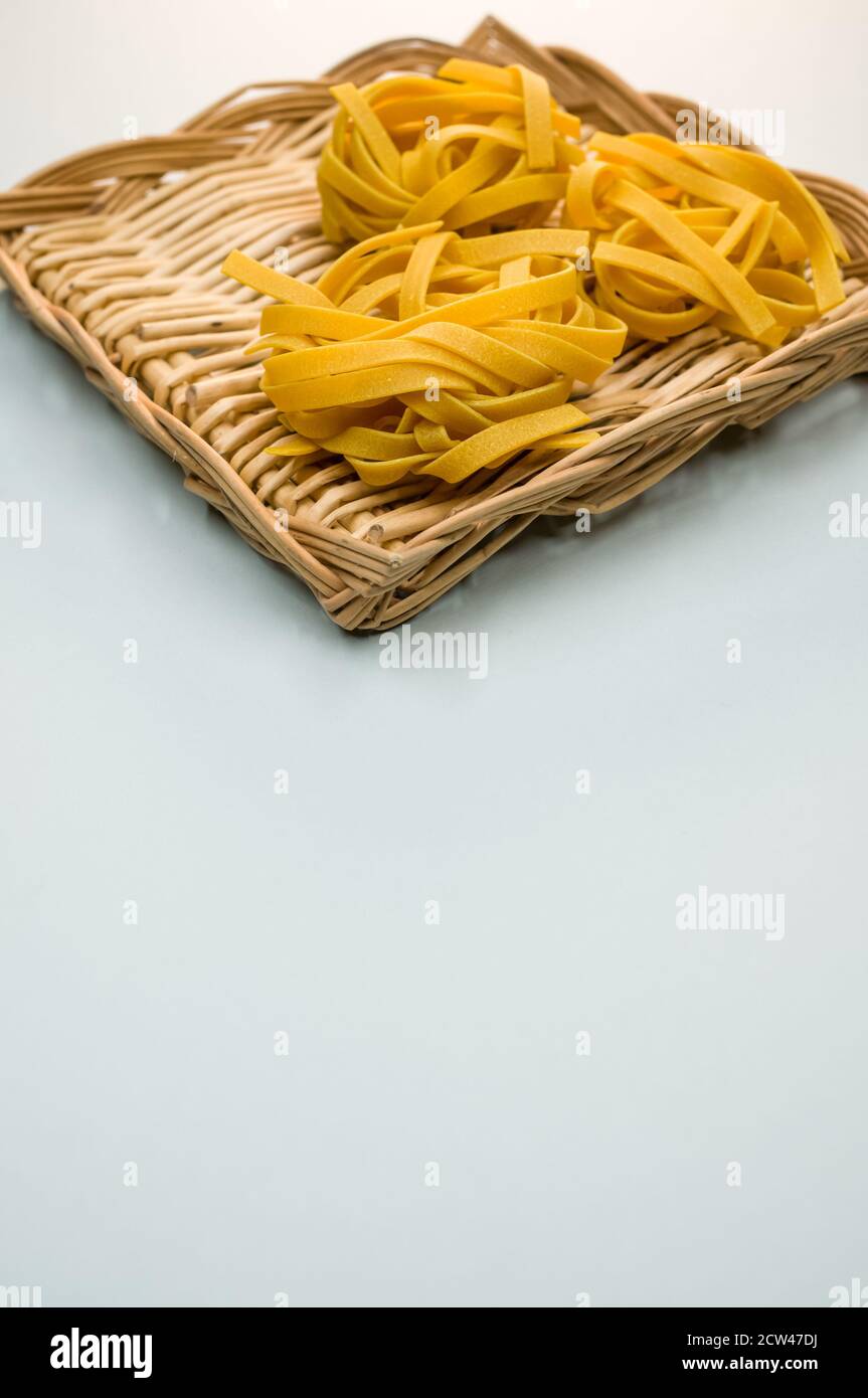 Vertical shot of tagliatelle pasta on a wicker plate Stock Photo - Alamy
