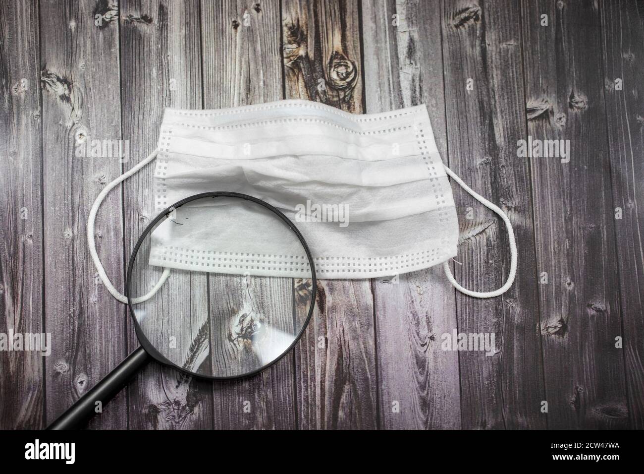 Covid-19 concept, face mask and magnifying glass Stock Photo - Alamy