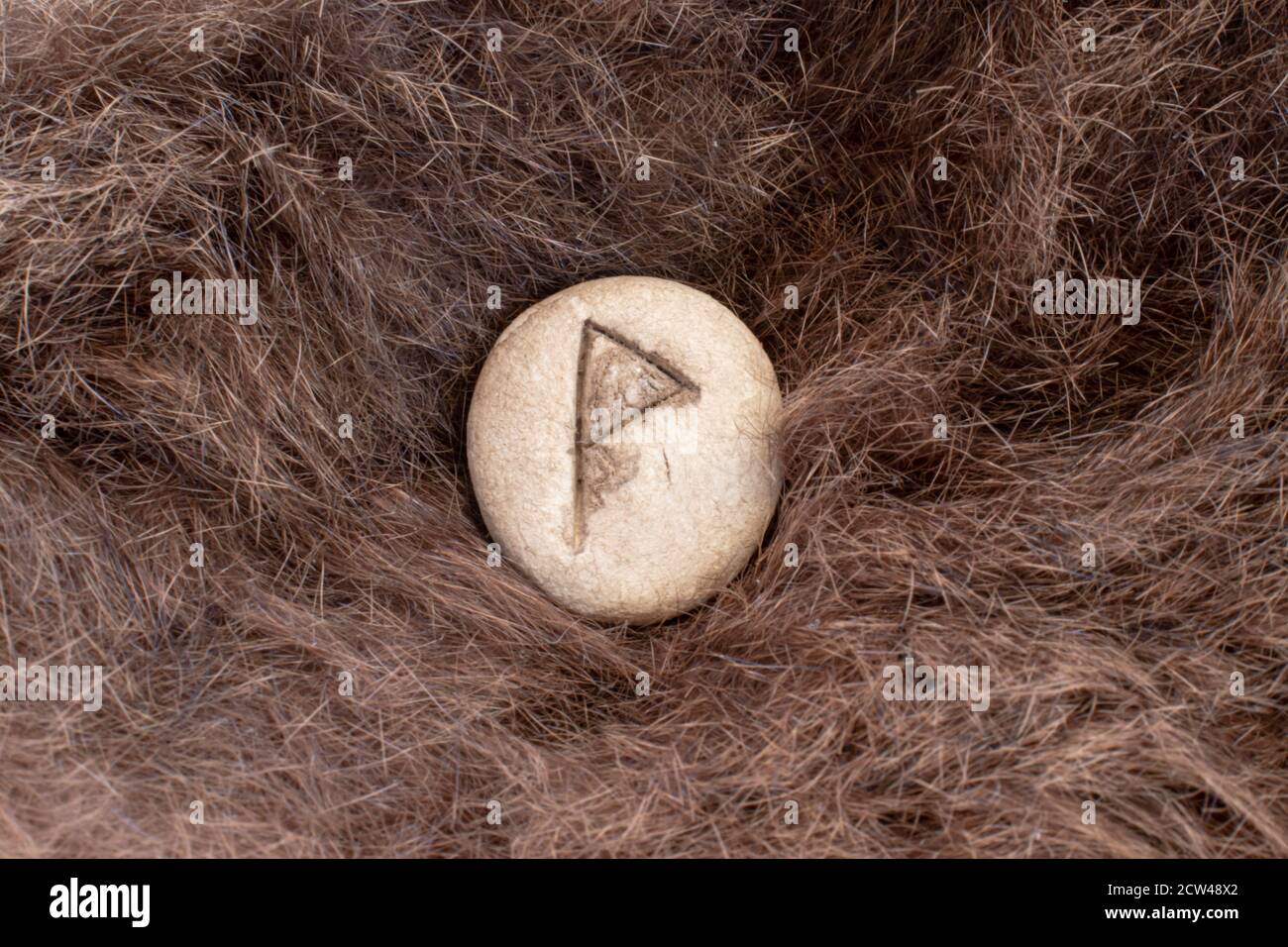 Wunjo Nordic stone rune on fur. Letter Wyn of the Viking alphabet Stock ...