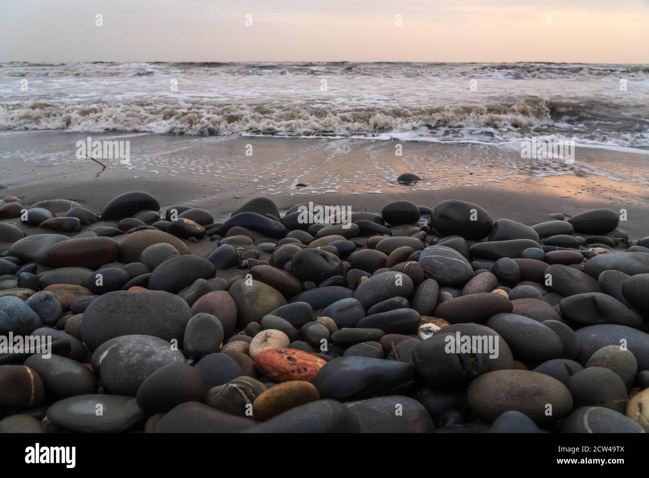 Pebbles on beach washed by waves at stormy weather Stock Photo - Alamy