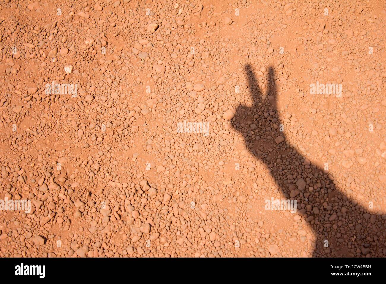 Shadow of hand with V sign on the red dirt background Stock Photo - Alamy