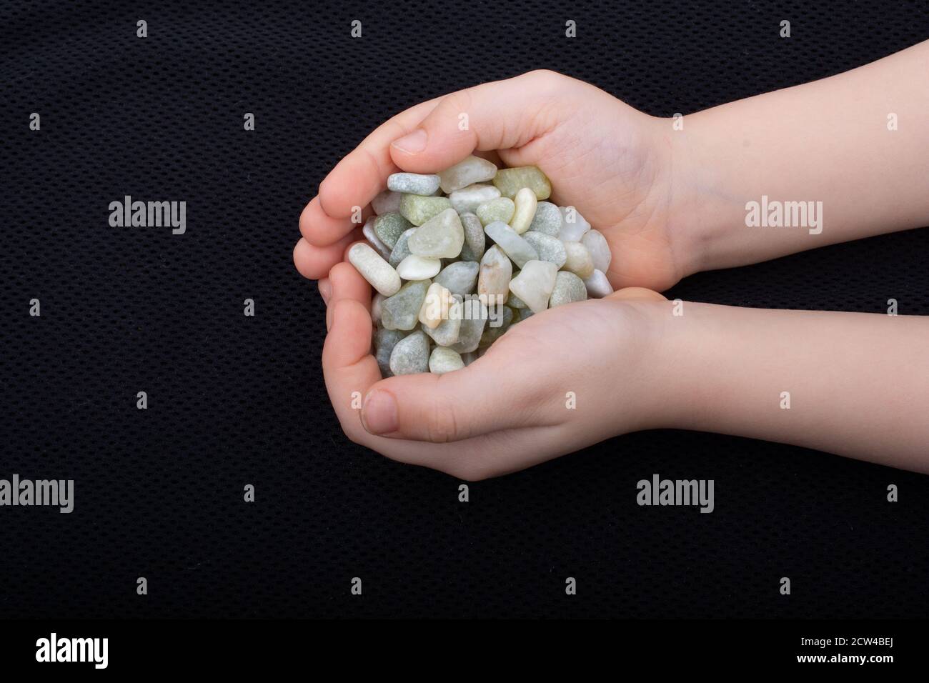 Handful of clean pebbles, gravels in hands Stock Photo - Alamy