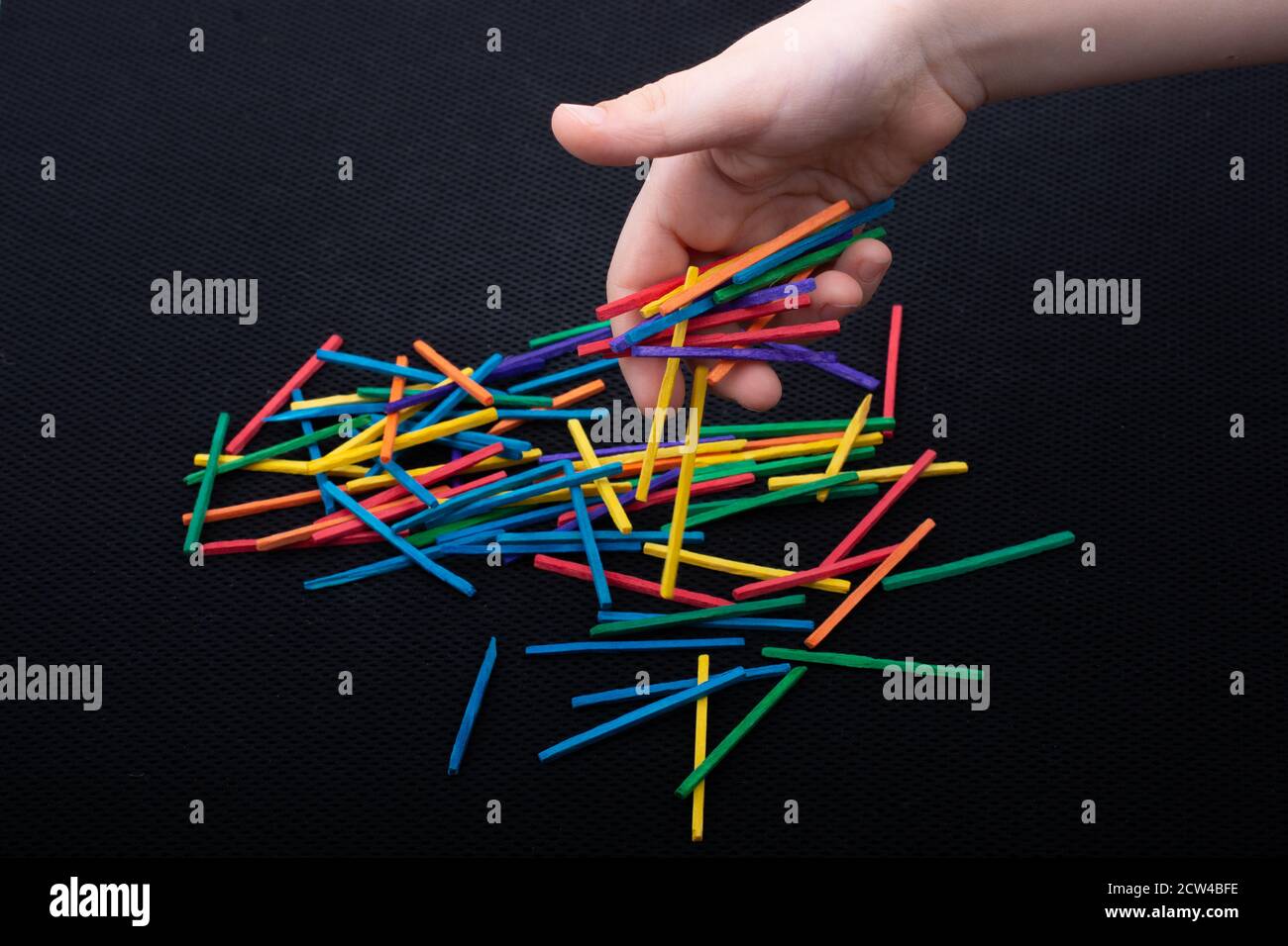 Beautiful coloured wooden sticks for creativity on black background ...
