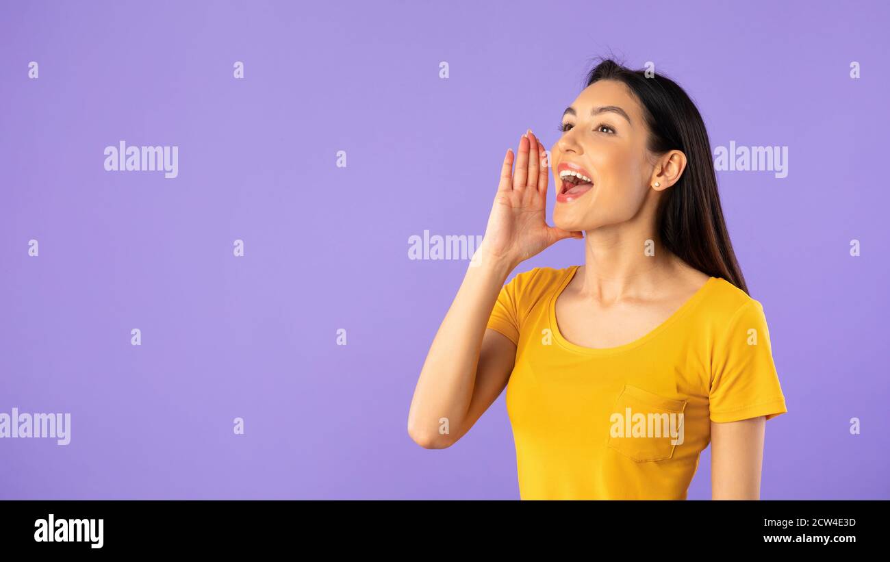 Lady holding hand near mouth, screaming aside at copyspace Stock Photo ...