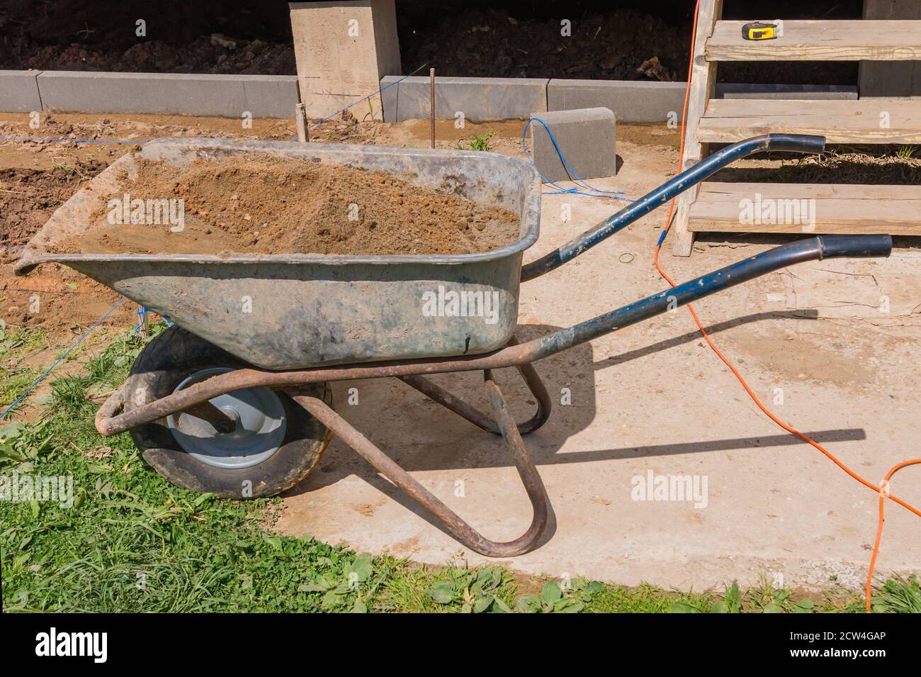 construction site with wheel barrow with sand Stock Photo - Alamy