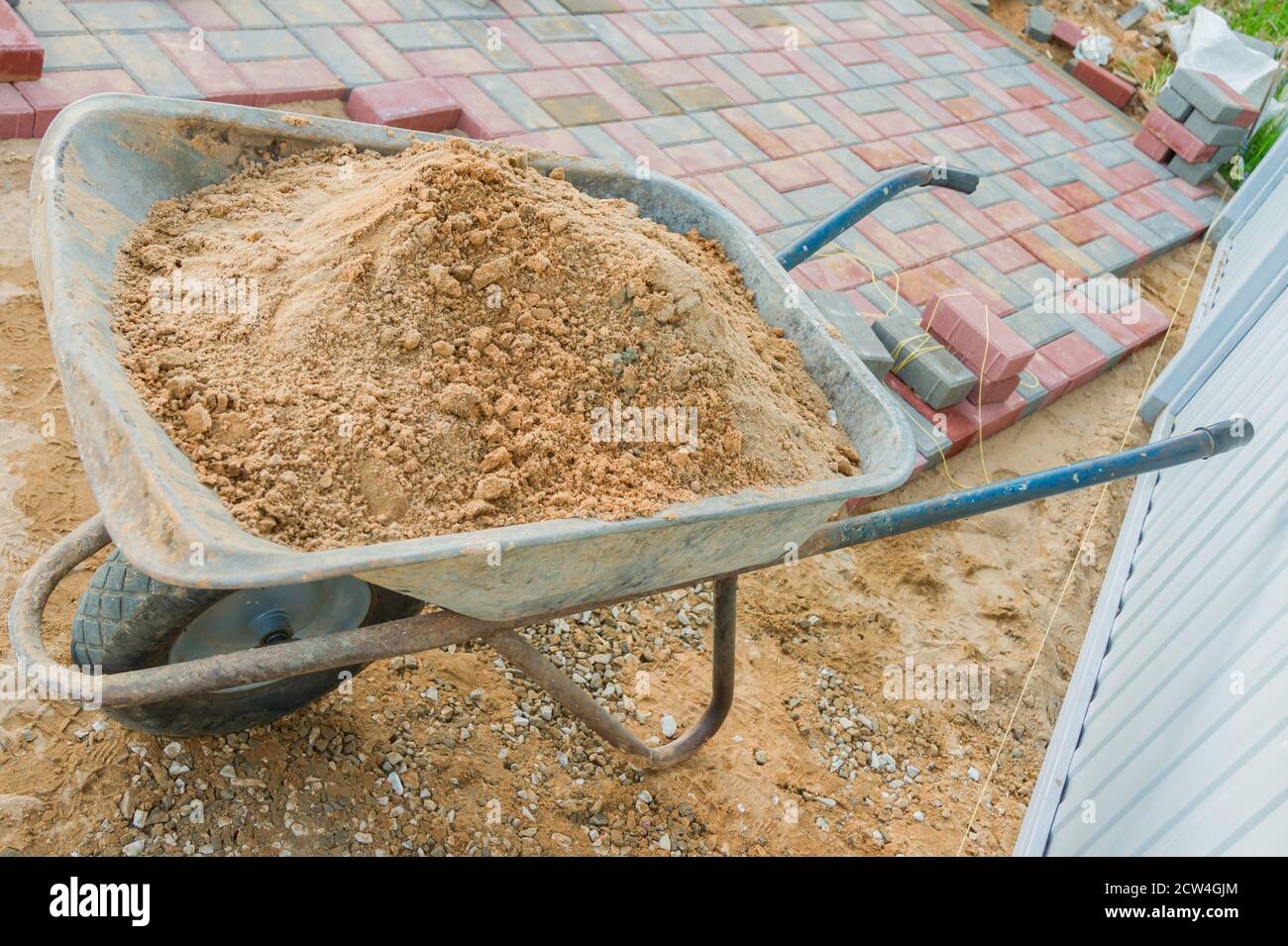 laying red and gray concrete paving blocks. Road Paving, construction ...