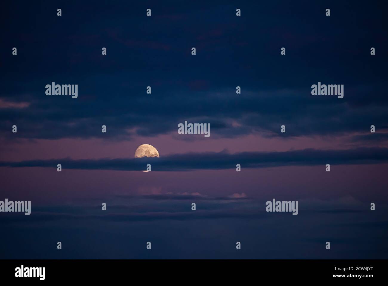 Moon rising behind clouds hi-res stock photography and images - Alamy