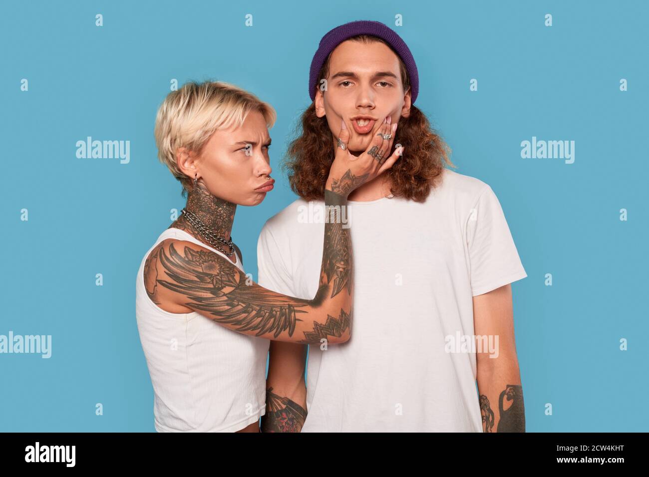 Funny woman touching man face, standing in studio Stock Photo - Alamy