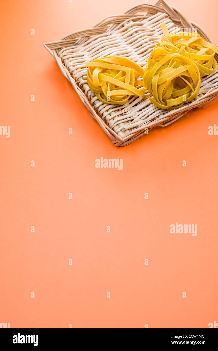 Vertical shot of tagliatelle pasta on a wicker plate Stock Photo - Alamy