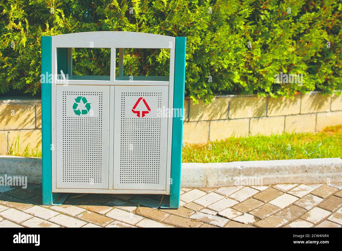 Trash can on the alley in the park area. Iron tank for different types ...
