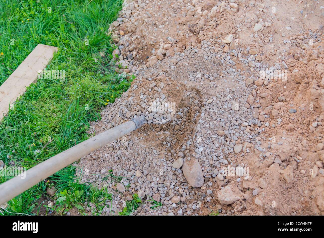worker mixing concrete and gravel with spade on construction cite Stock ...