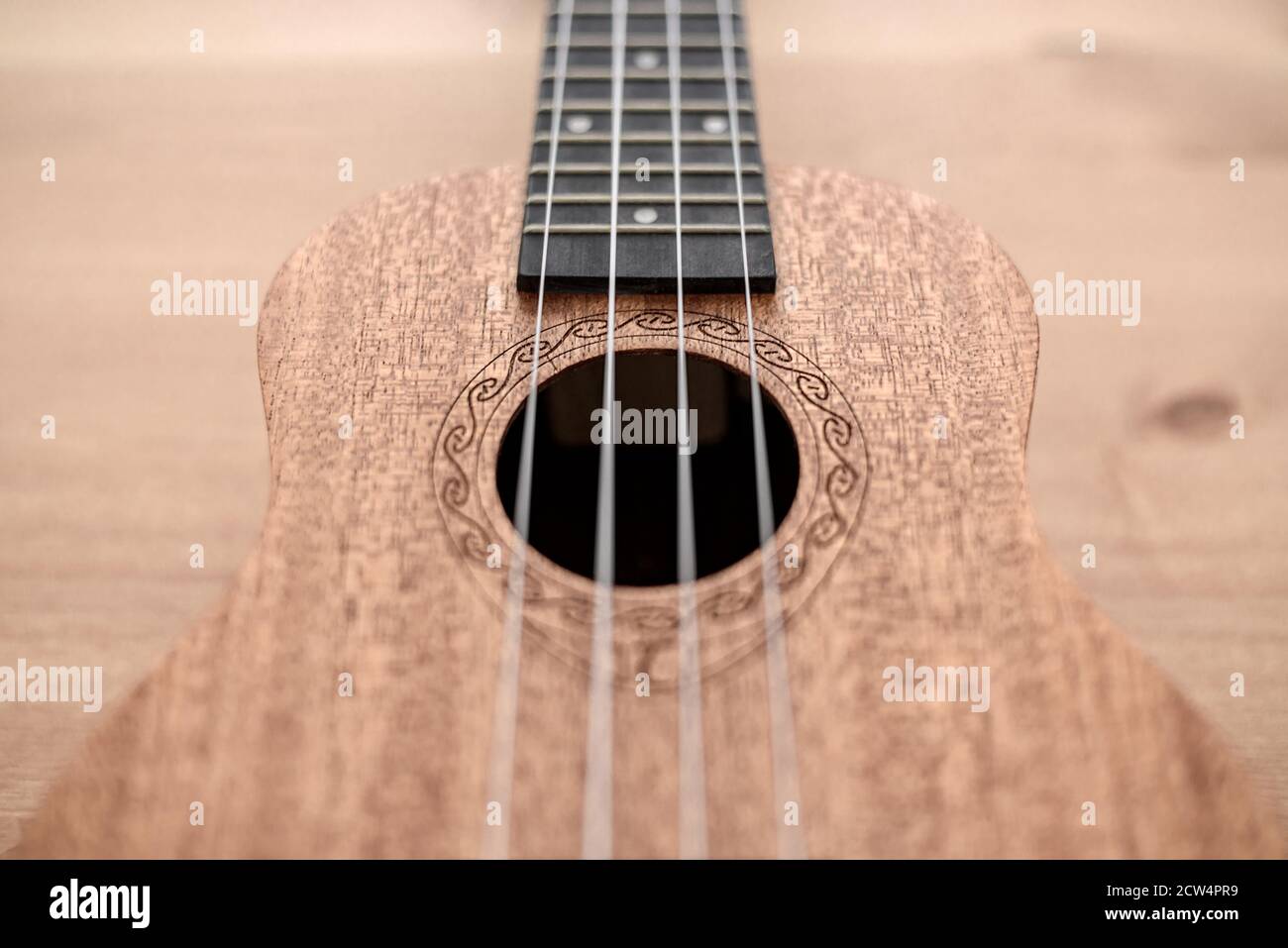 Brown ukulele on wooden background with shallow depht of field Stock ...