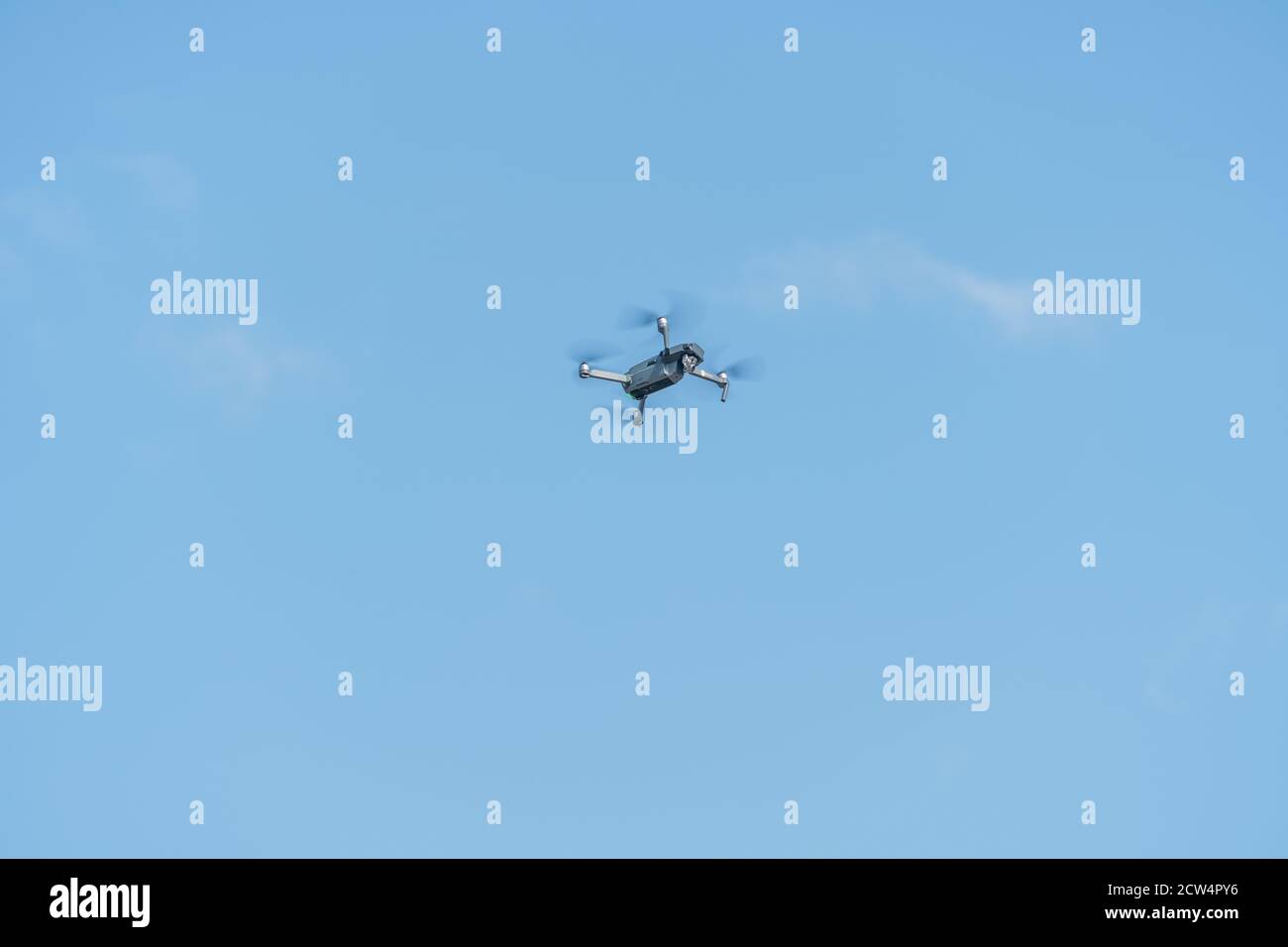 Professional filming drone flies in the air at a low altitude against a ...