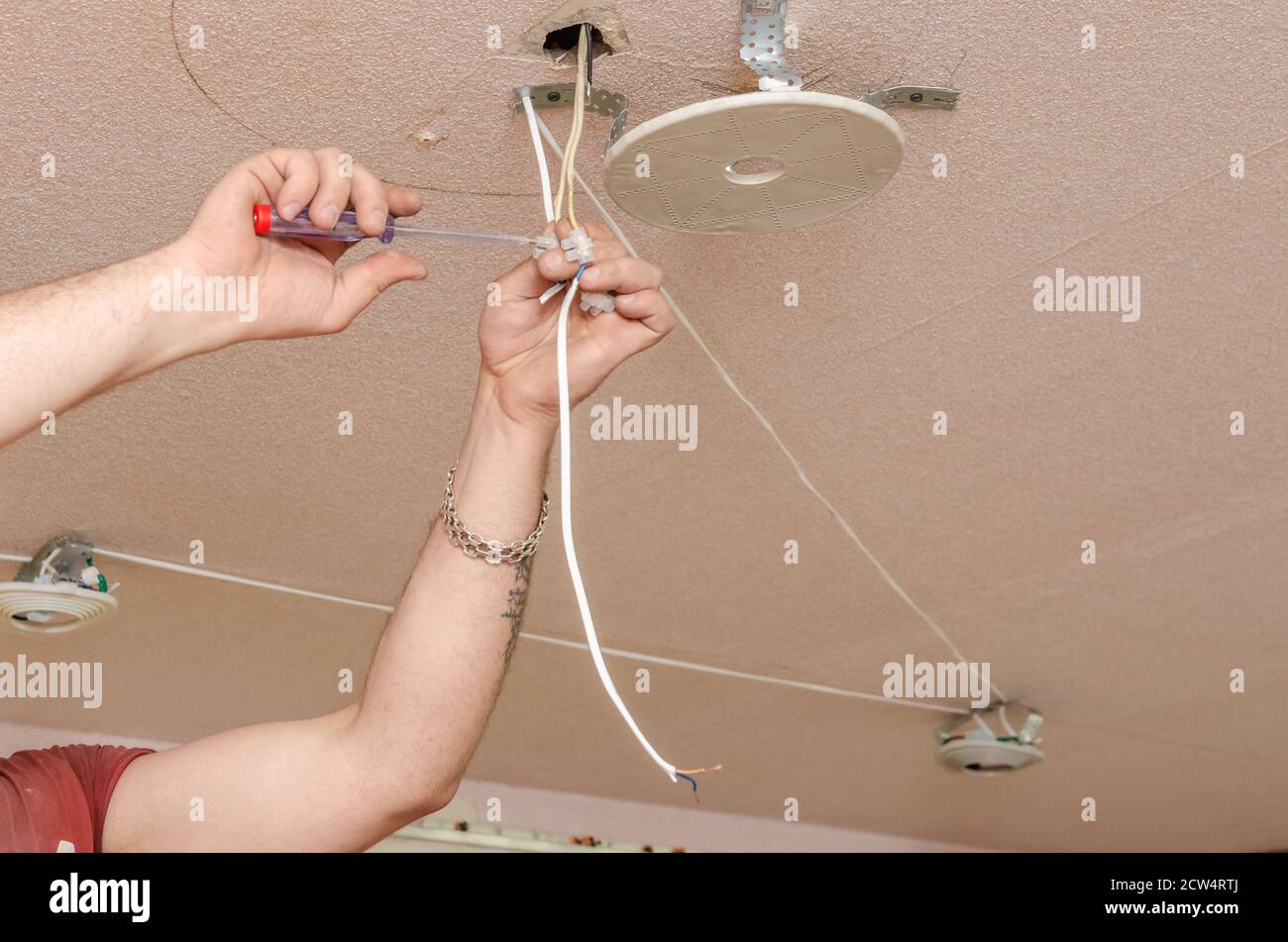 Electrician repairing ceiling light Stock Photo - Alamy