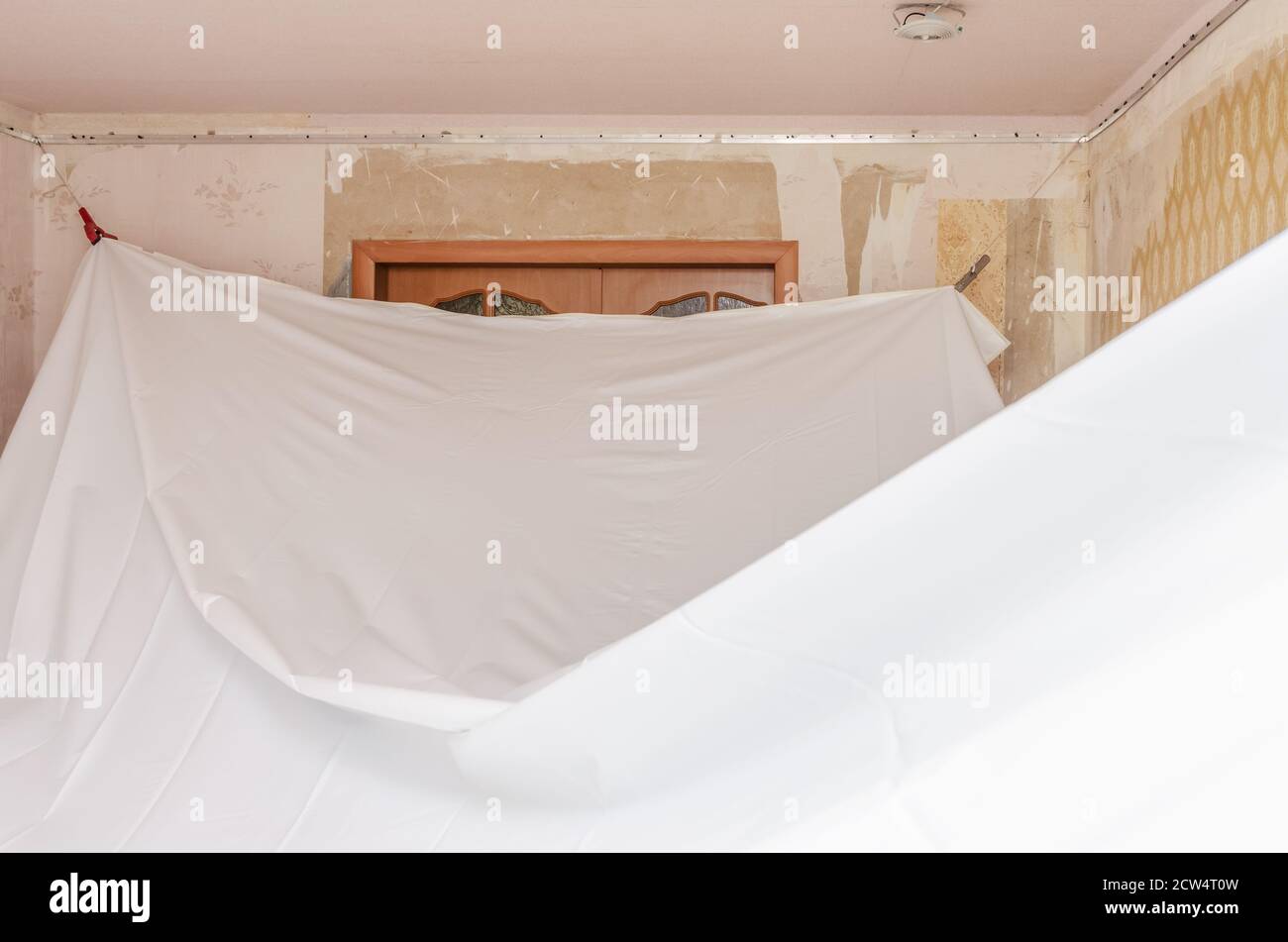 repairmen install stretch ceiling made of pvc vinyl film using a gas ...