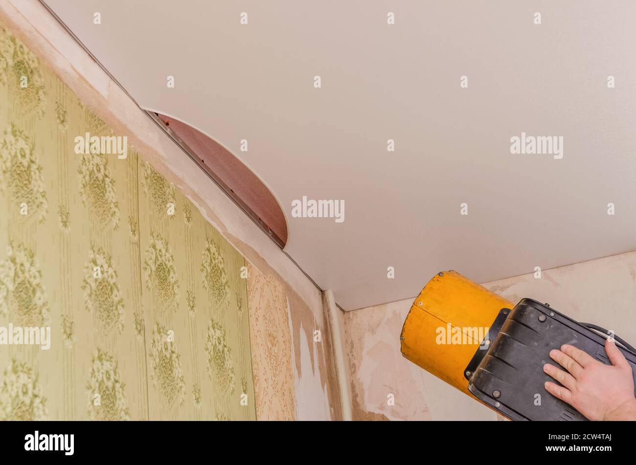 installation of stretch ceiling using a gas heater. Installer performs ...