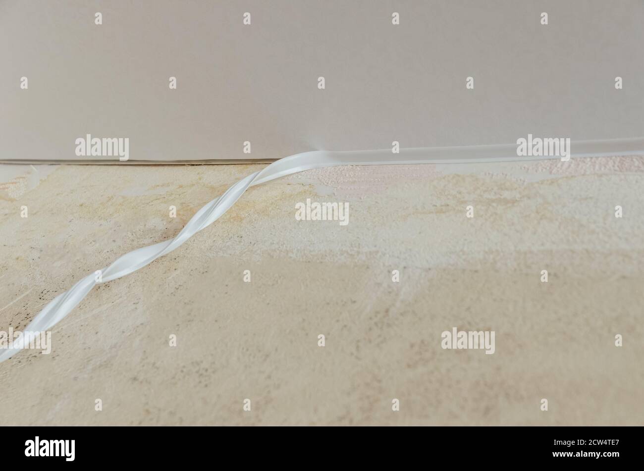 The worker pulls the stretch ceiling in the room, puts the plinth ...