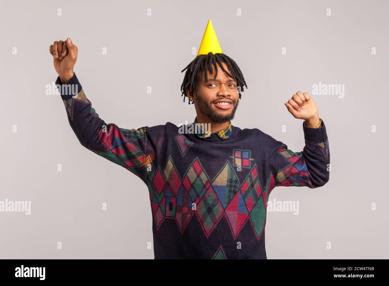 Happy satisfied african man with dreadlocks wearing party cap on head ...