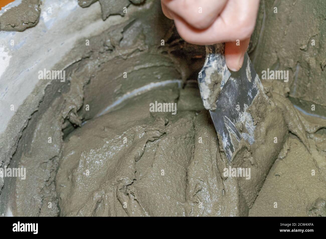 female hand kneads cement mortar for tiling in an apartment. kneading ...