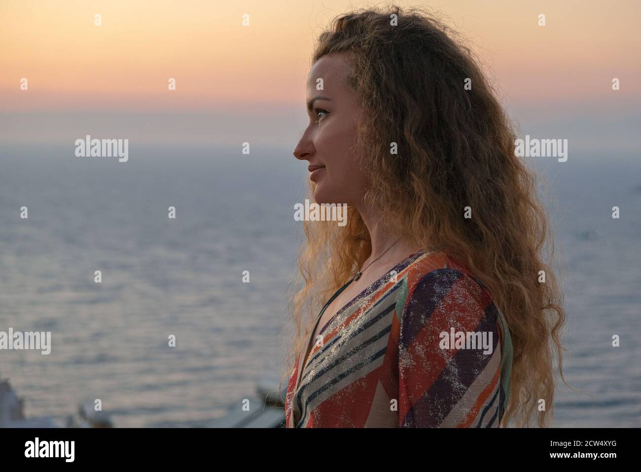 woman face looking at sunset and sea view from terrace of luxury ...