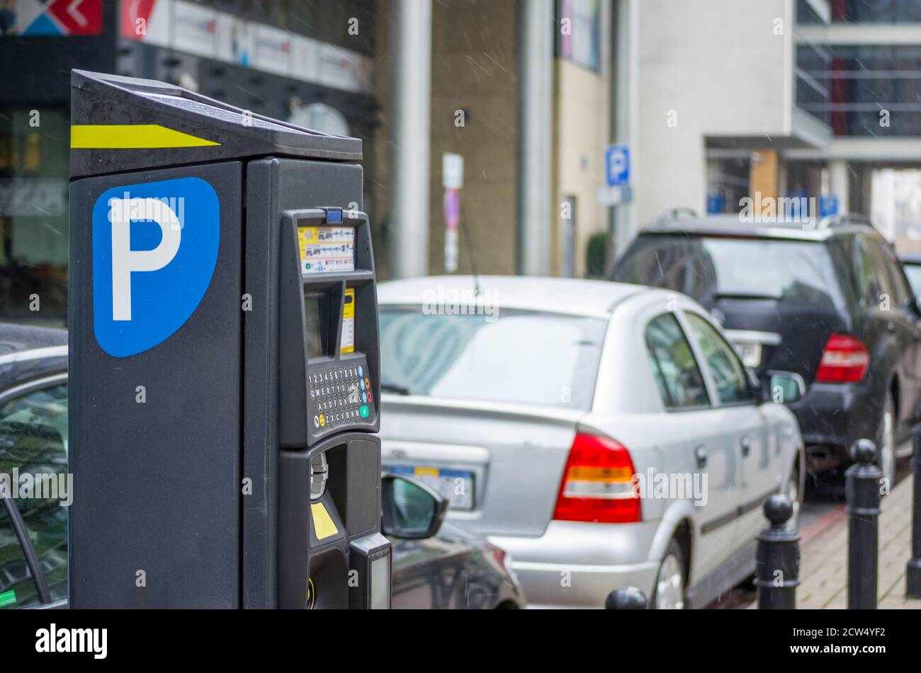Parking meter machine on the street. Ticket pay station with cars on ...