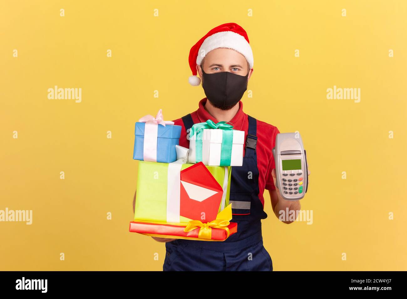 Postman in uniform overalls and santa claus hat with medical protective ...