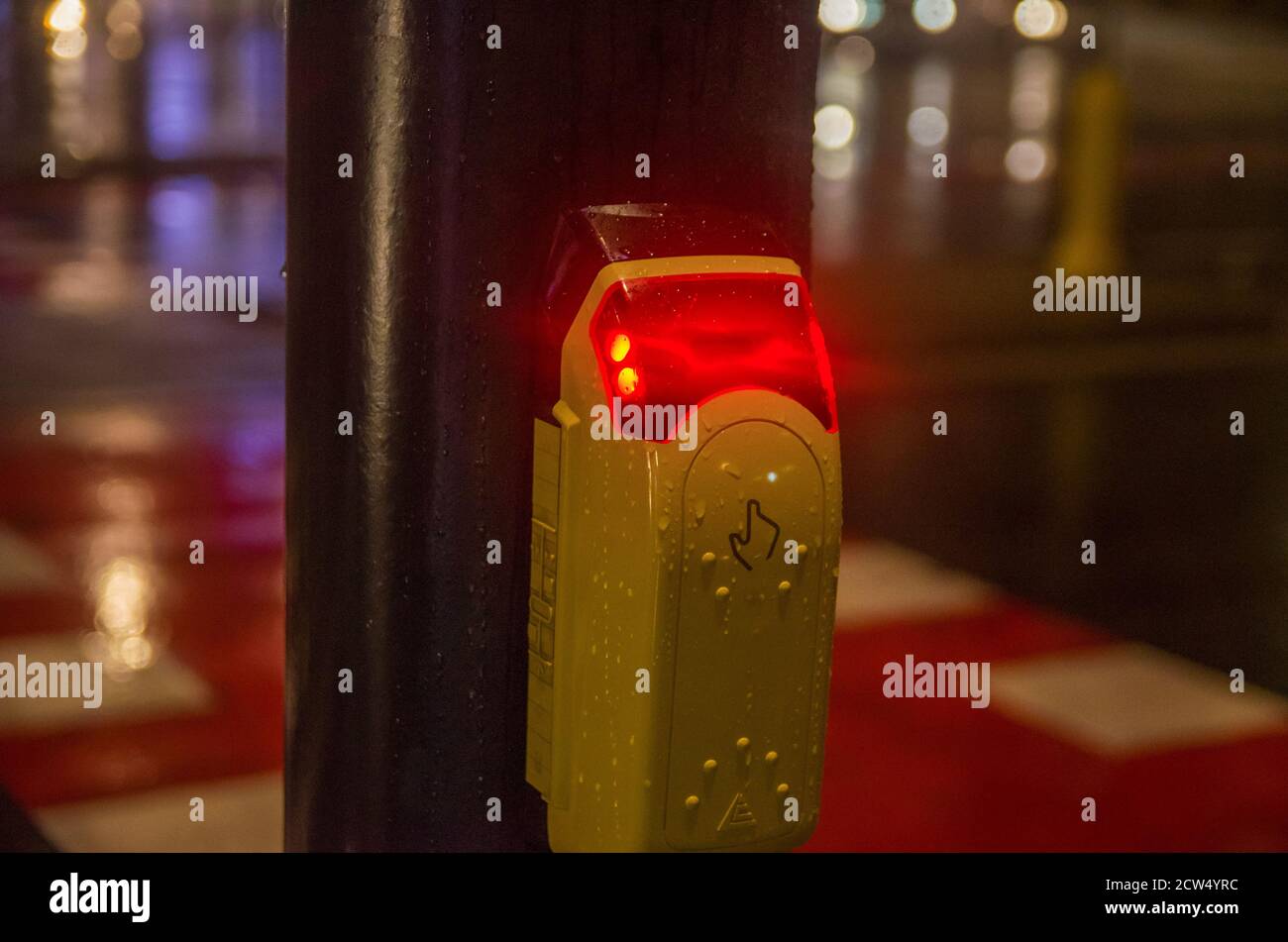 Hand pushing control button on pedestrian crossing to activate the ...