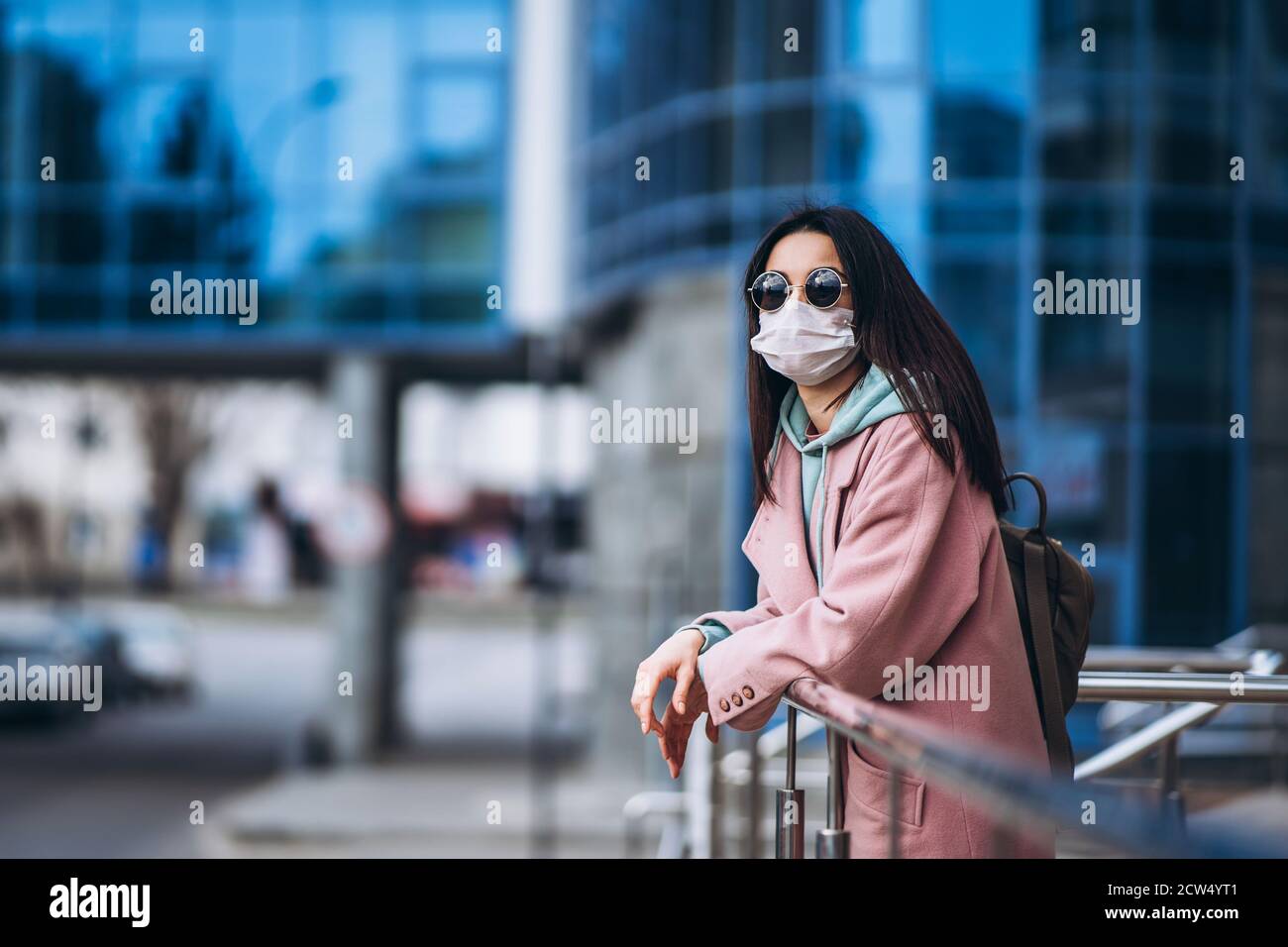 Female in medical mask outdoors in the empty city. Health protection ...