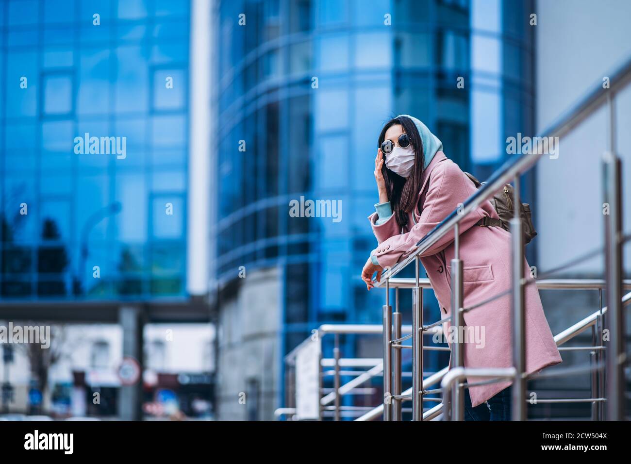 Female in medical mask outdoors in the empty city. Health protection ...