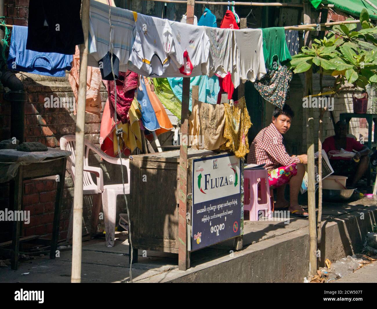 People drying clothes in the sun in the street in central Yangon ...