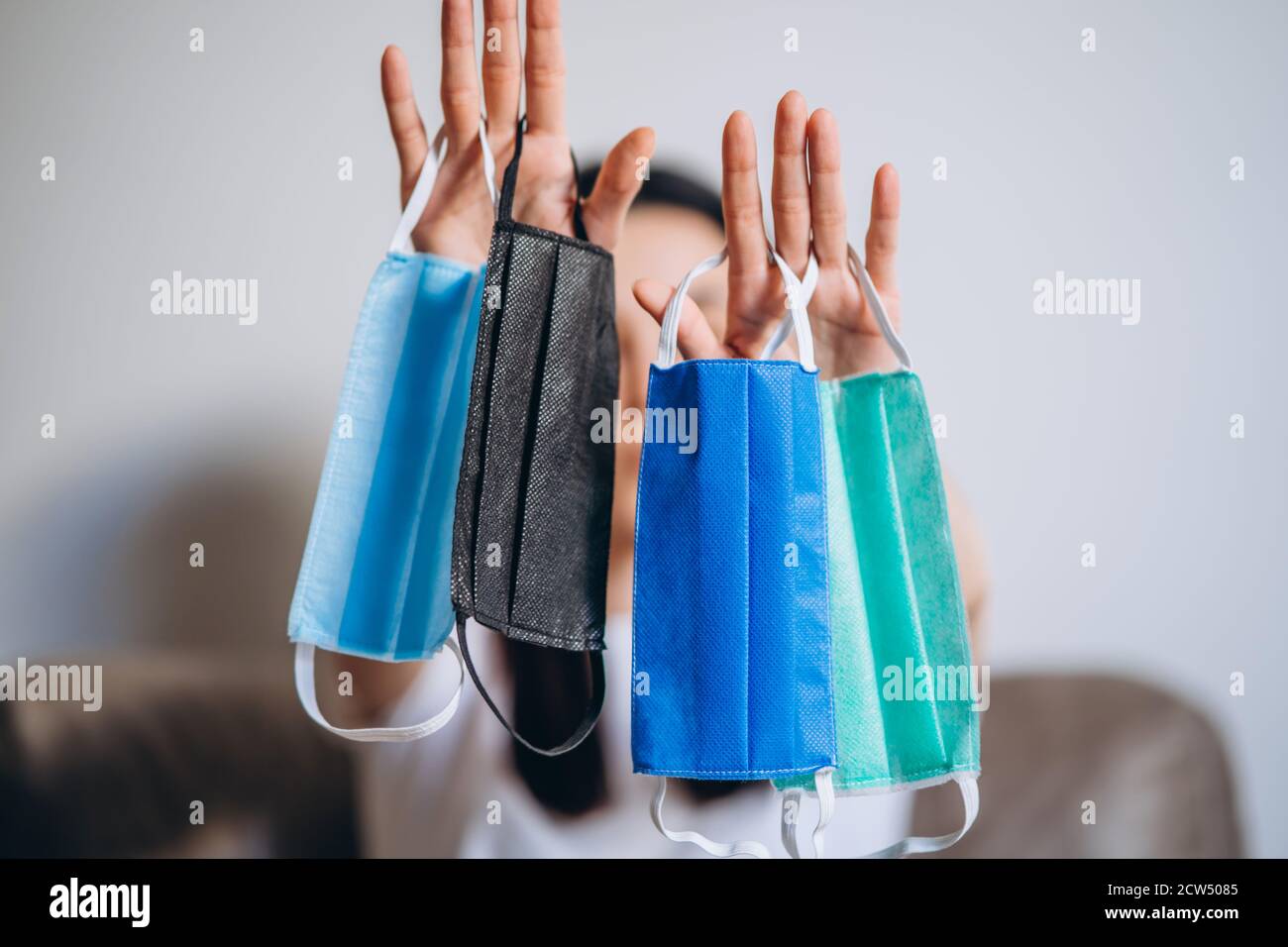 Female at home in quarantine time holding colorful protective medical ...