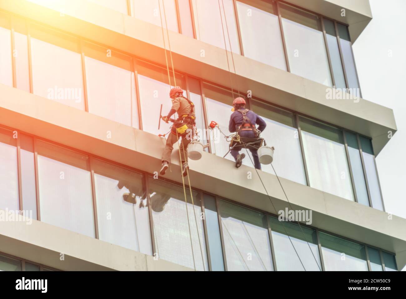 Two workers clean the exterior of a building hi-res stock photography ...