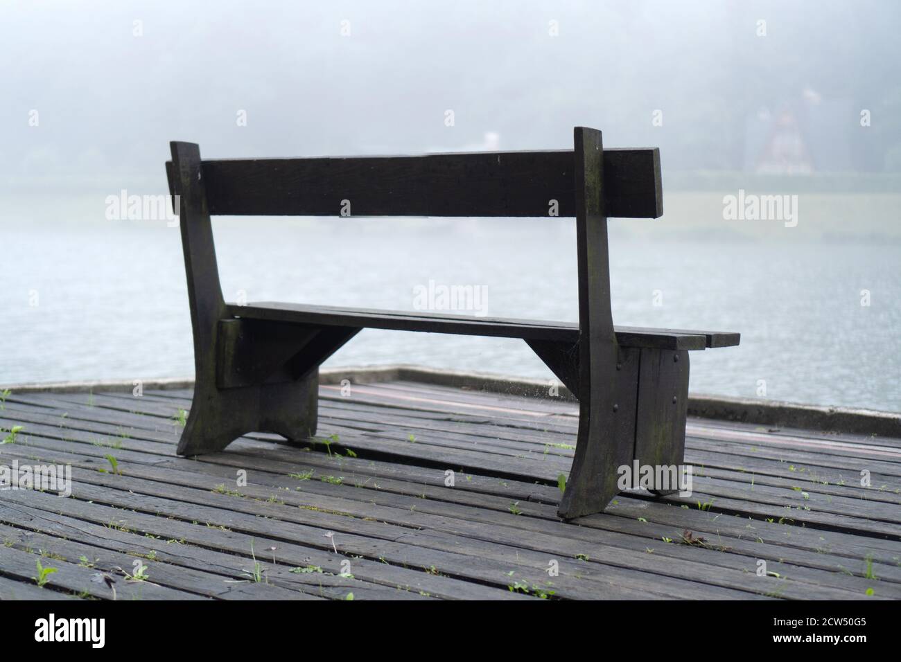 Wooden bench in the fog near the lake. Empty bench near lake. Bench ...