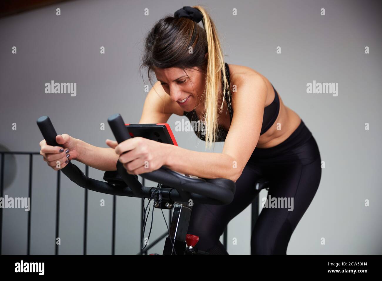 woman spinning at home exercising for their legs and cardio training ...