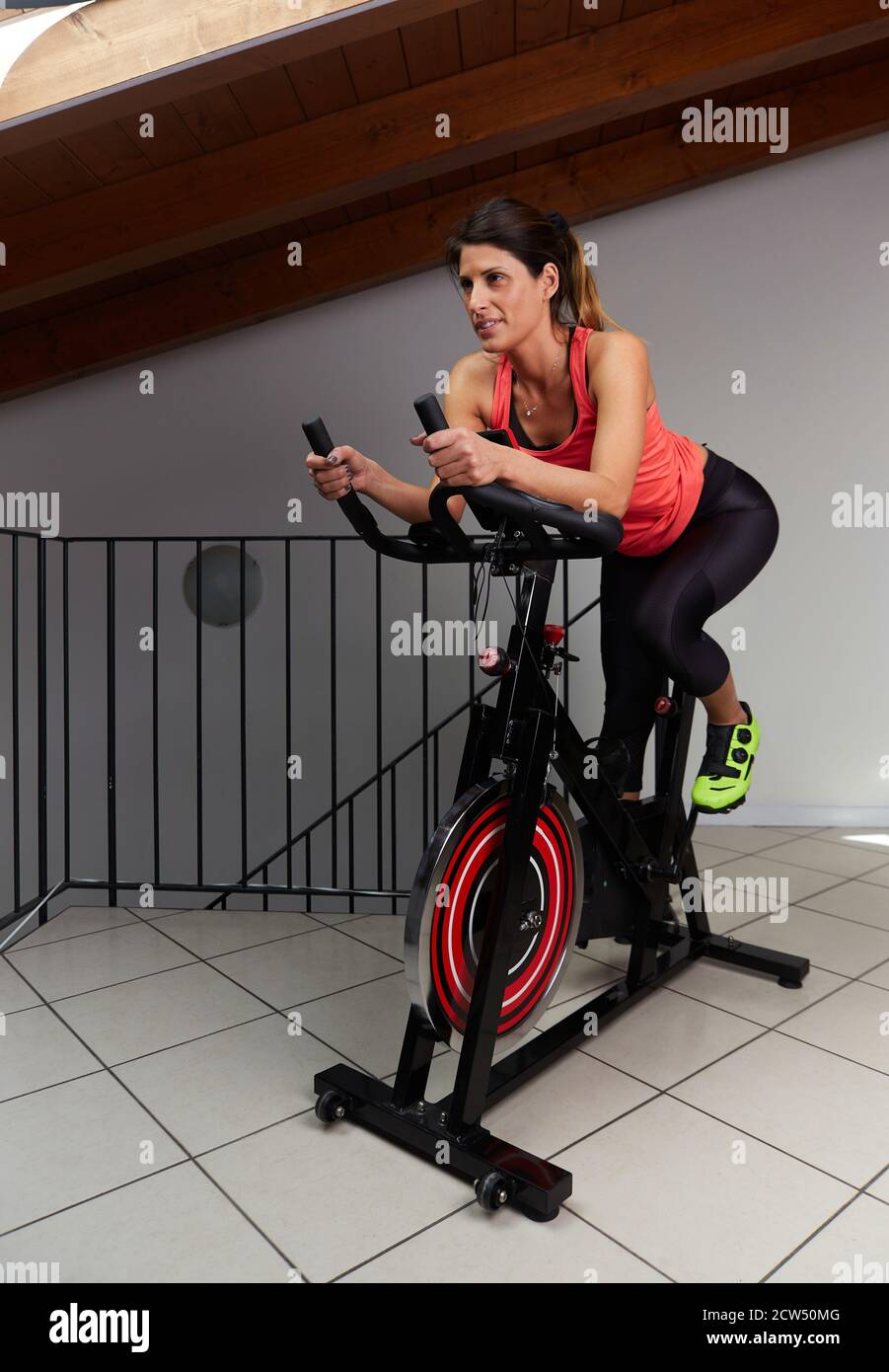 woman spinning at home exercising for their legs and cardio training ...