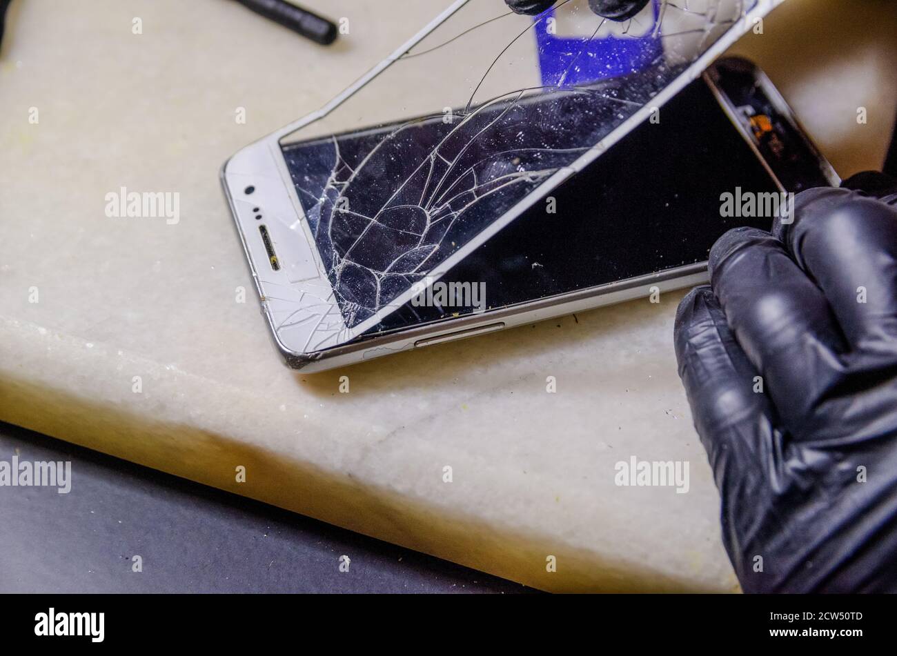 Technician or engineer opening broken smartphone for repair or replace ...