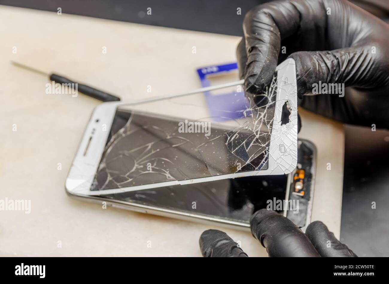 Technician or engineer opening broken smartphone for repair or replace ...