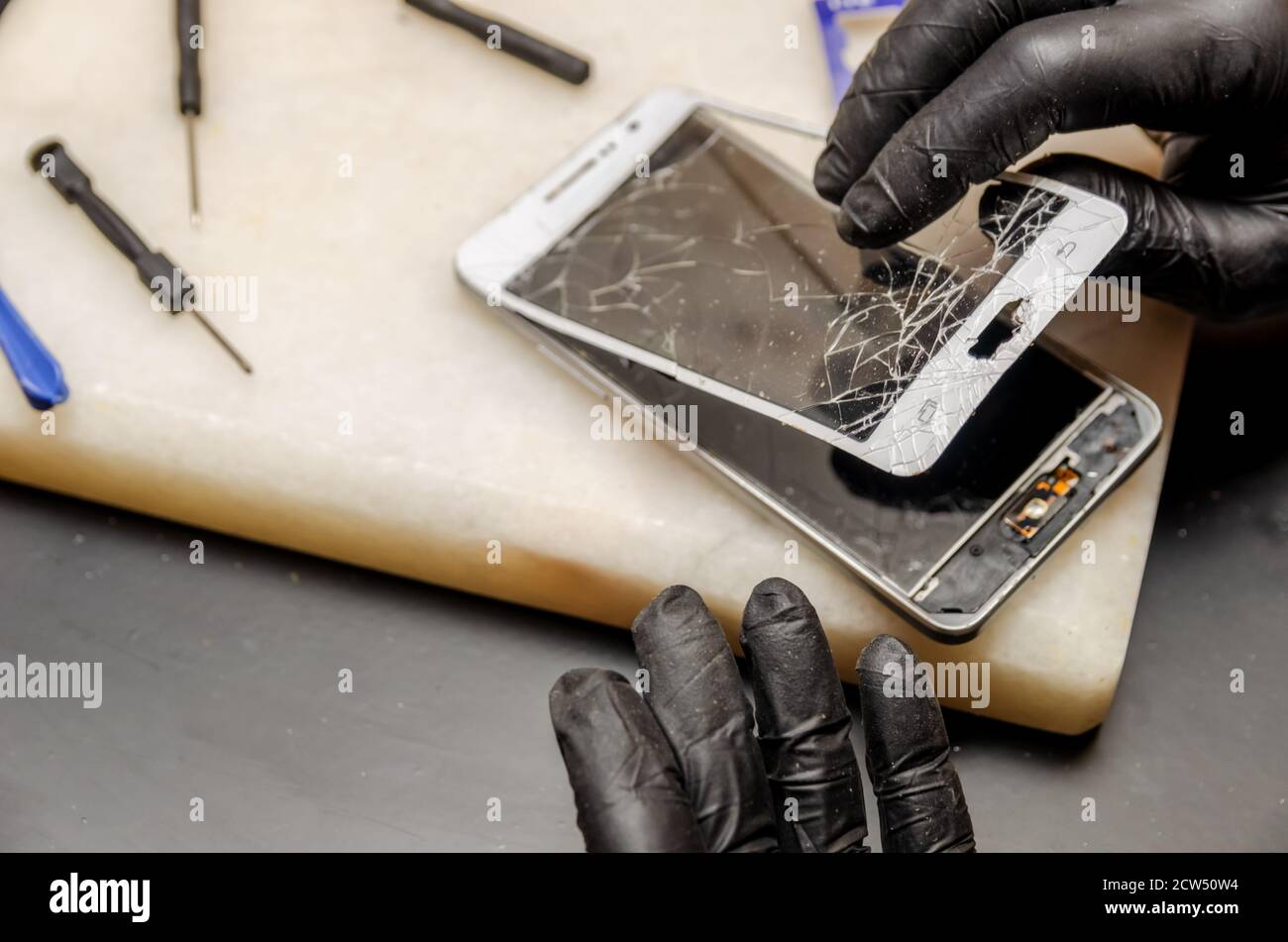 Technician or engineer opening broken smartphone for repair or replace ...