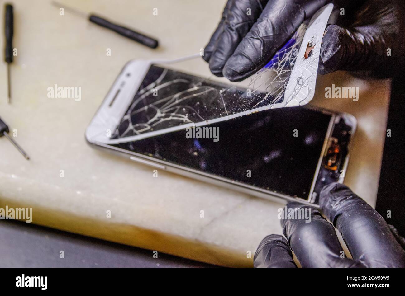 Technician or engineer opening broken smartphone for repair or replace ...