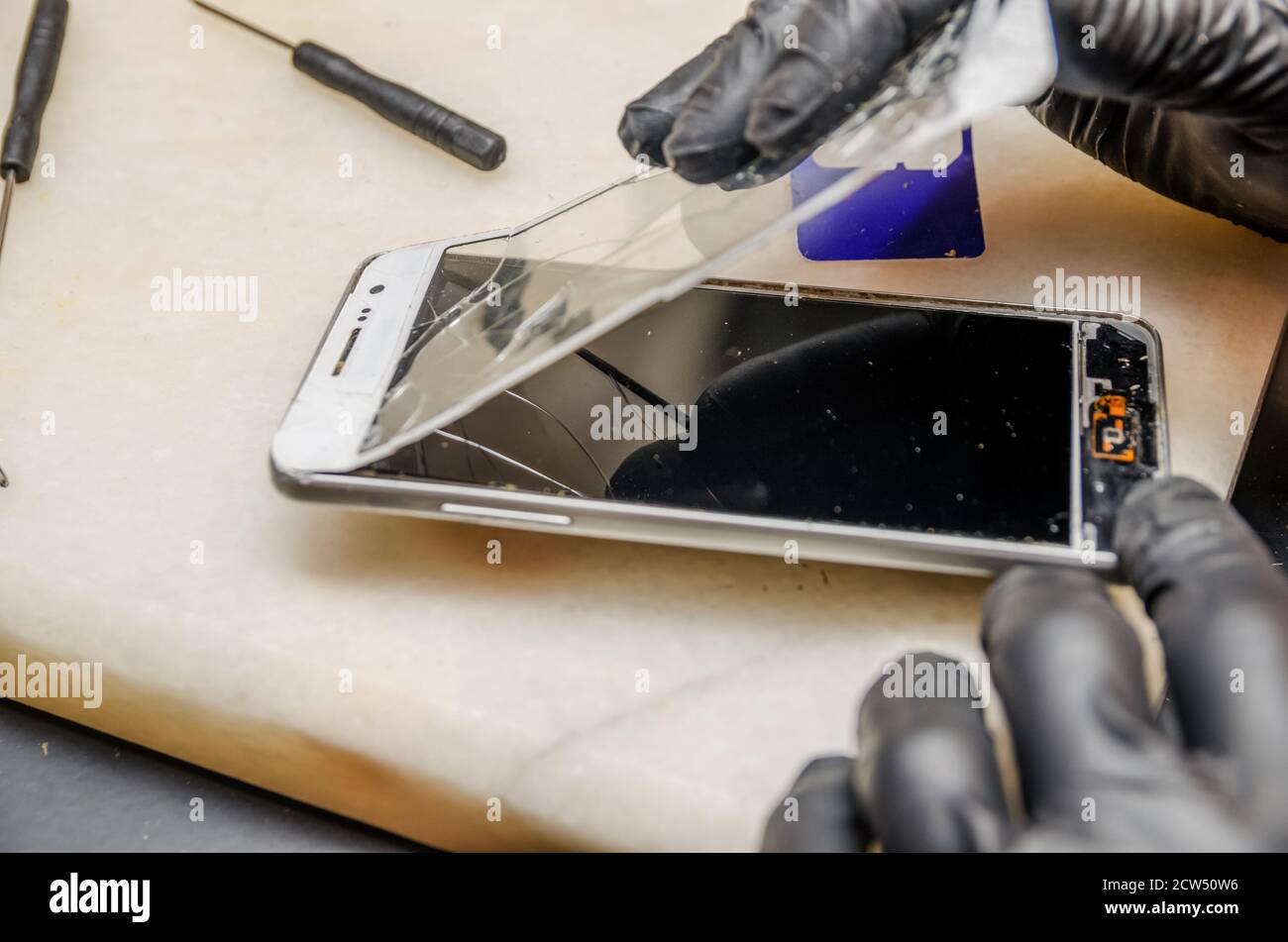 Technician or engineer opening broken smartphone for repair or replace ...