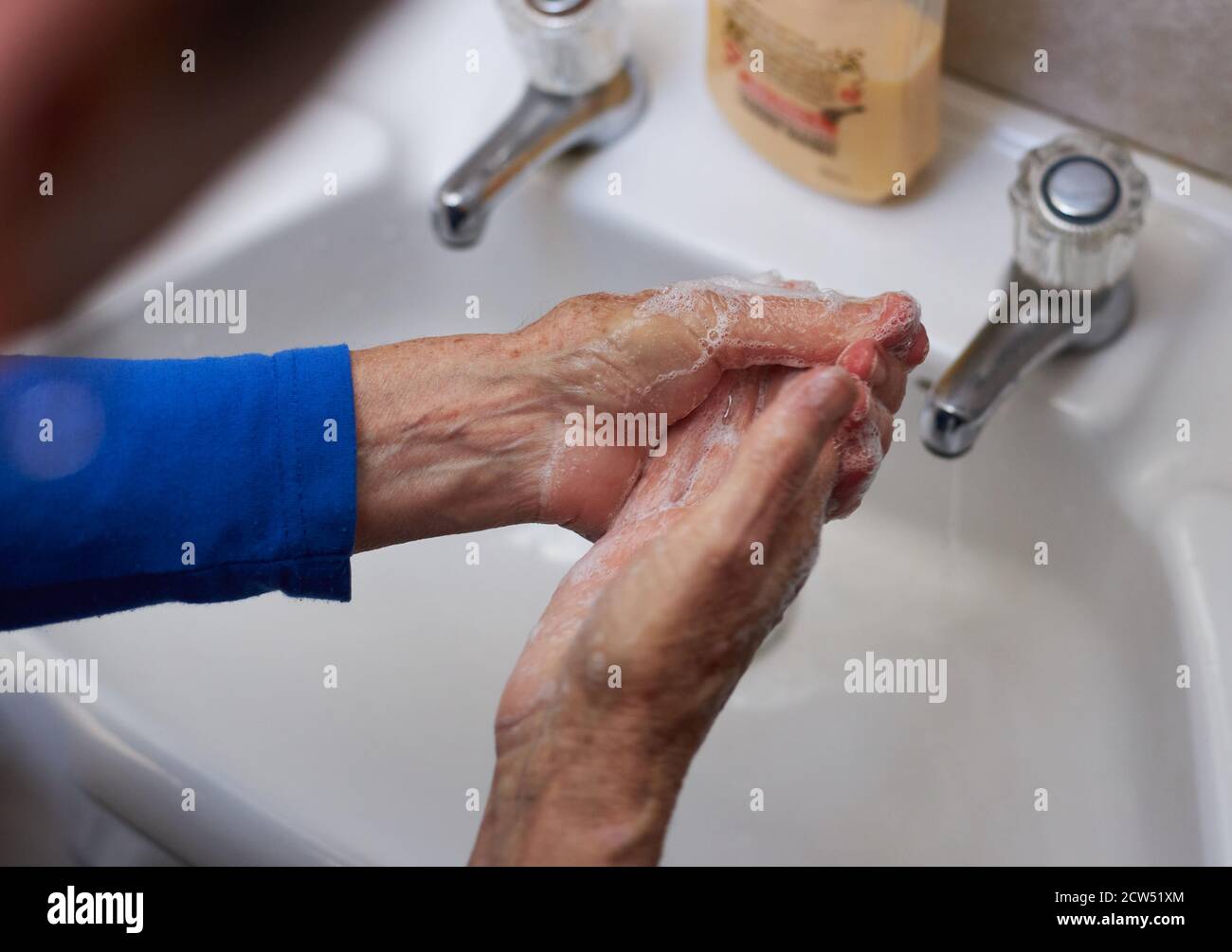 Close Up Of Senior Woman Washing Hands In Washbasin During Health ...