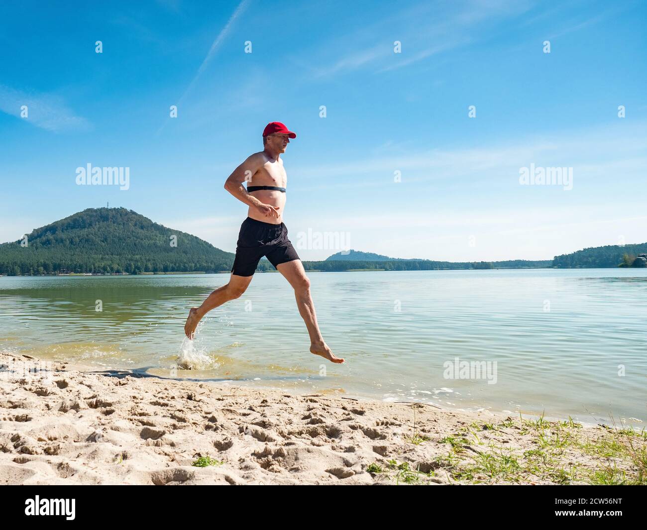 Runner run in water at beach, water drops refreshing his body in hot ...