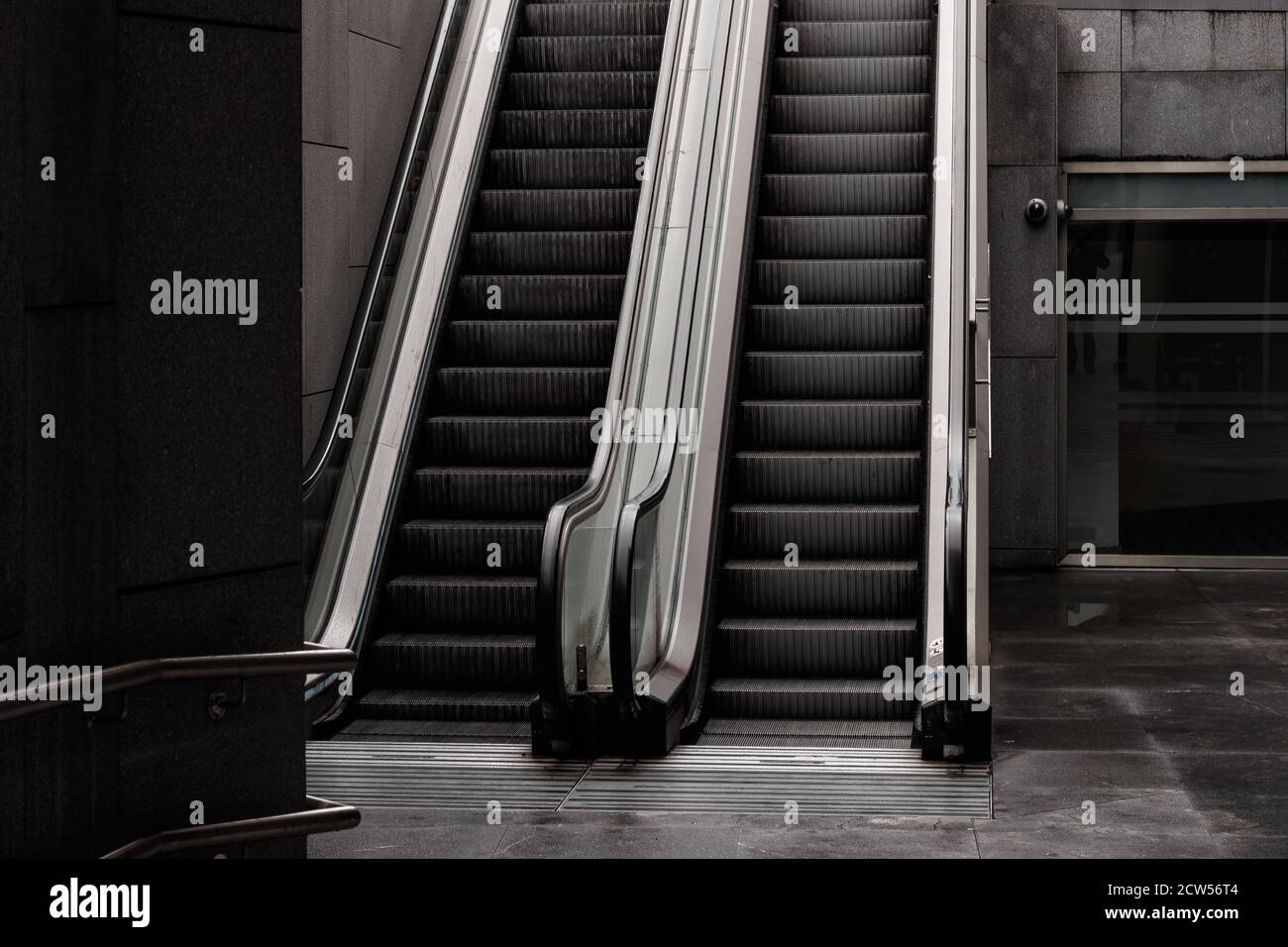Grayscale shot of escalators in a building at daylight Stock Photo - Alamy