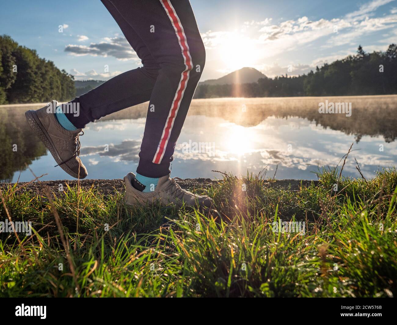 Athlete man or boy is running at lake in summer outdoors wearing. Blue ...