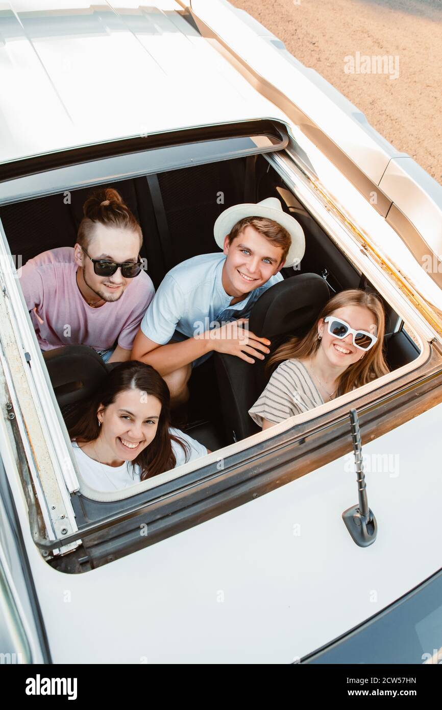 group of friends in car looking up through sunroof Stock Photo - Alamy
