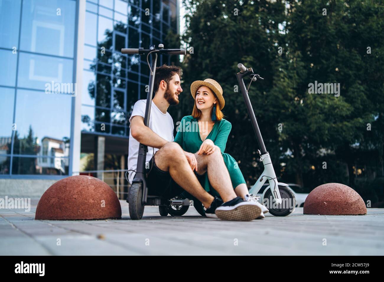 Couple of two attractive people are chilling near the glass building ...