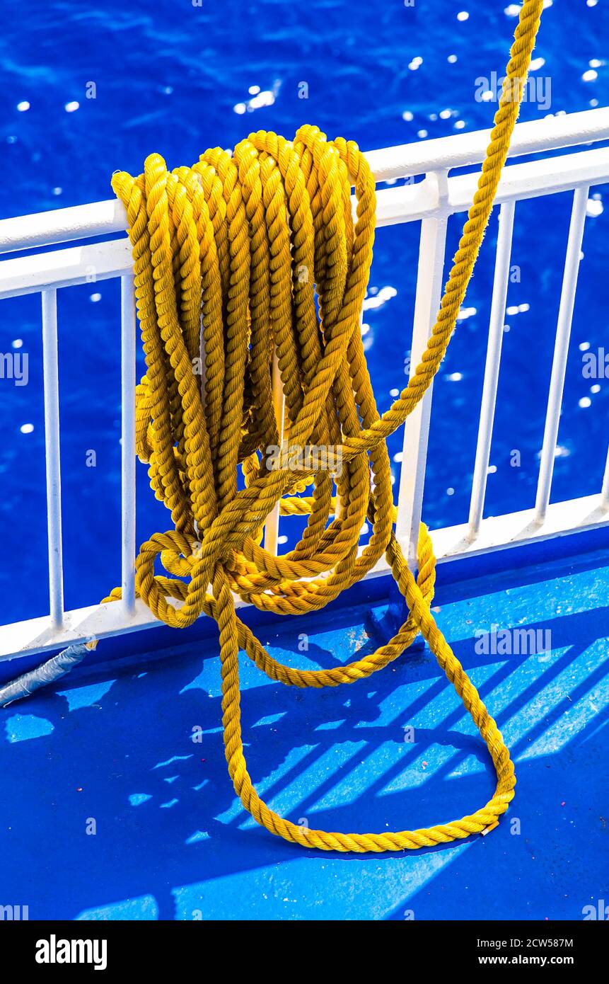 Yellow braided rope draped over a ship railing Stock Photo - Alamy