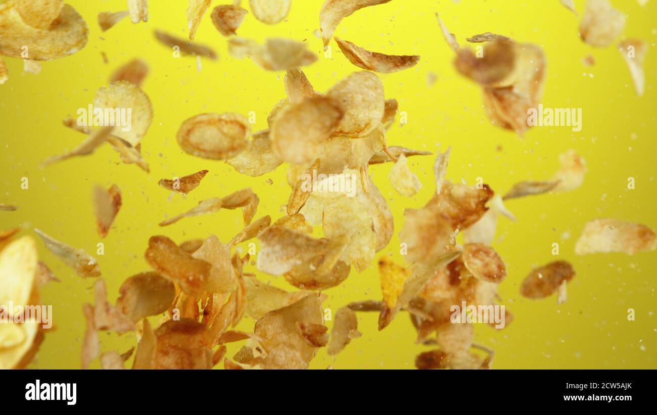 Flying potatoes chips up in the air in freeze motion. Isolated on ...